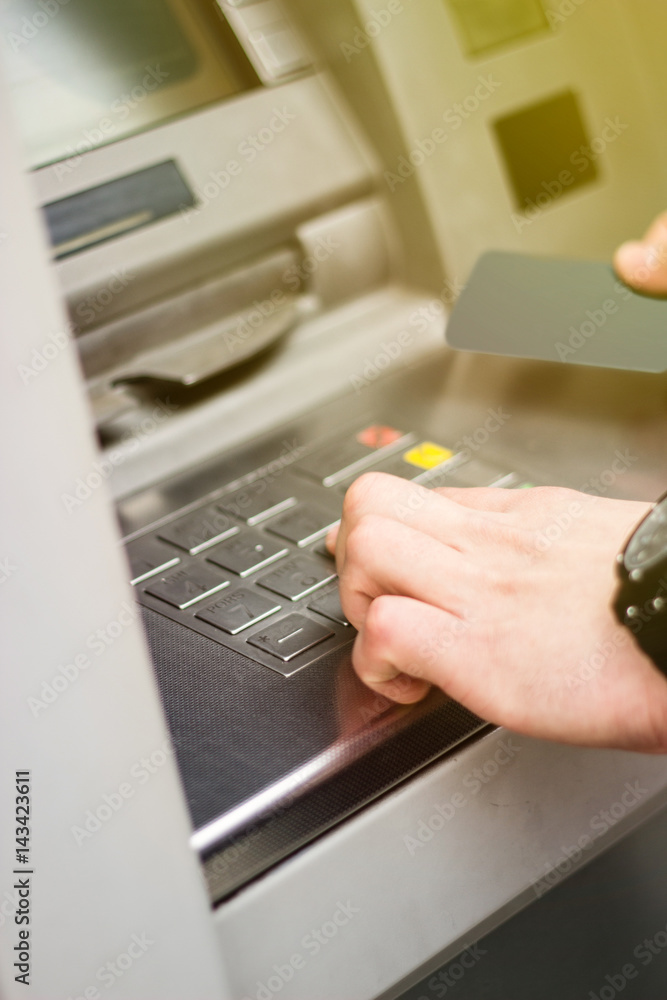 Hand of a man with a credit card, using an ATM. Man using an atm ...