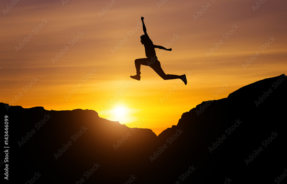 Silhouette of athlete, jumping over rocks in mountain area against ...