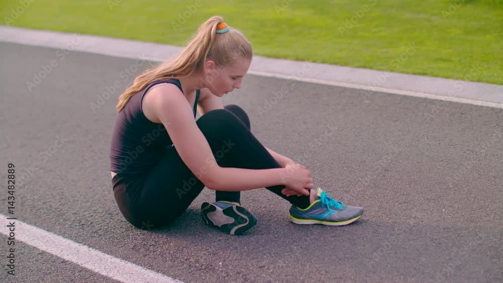 Exhausted woman sitting on asphalt road after running marathon. Tired ...