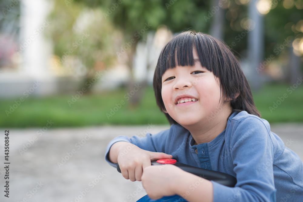 Asian child driving blue toy car outdoors Stock Photo | Adobe Stock