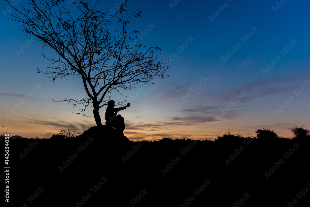 silhouettes Man sitting under the tree Stock Photo | Adobe Stock