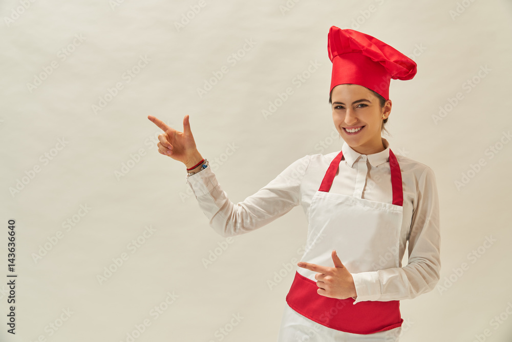Beautiful woman chef holding out hand in presentation and showing ...