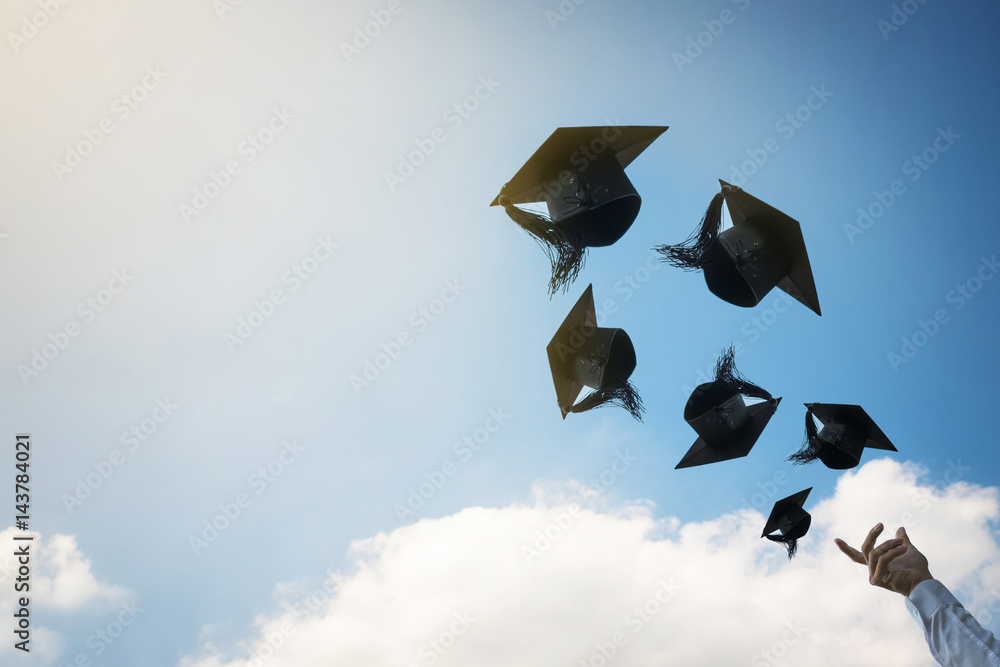 Graduates hands throwing graduation hats. Stock Photo | Adobe Stock