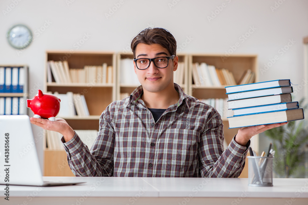 Young student breaking piggy bank to buy textbooks Stock Photo | Adobe ...