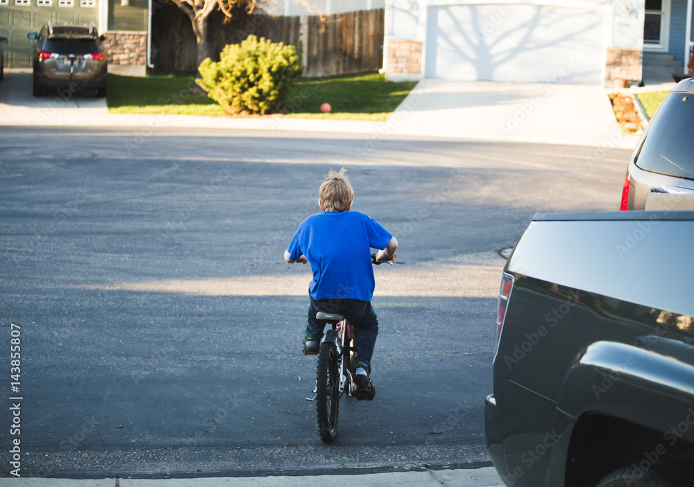 Young Boy Riding Bike on Street Stock Photo | Adobe Stock