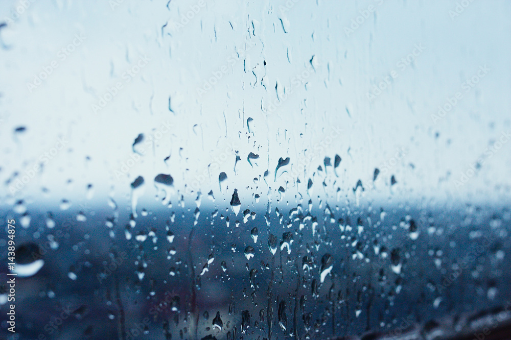 Textures of water droplets of rain flow down the windowpane ...