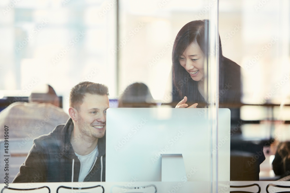 University students working at computer behind glass partition Stock ...