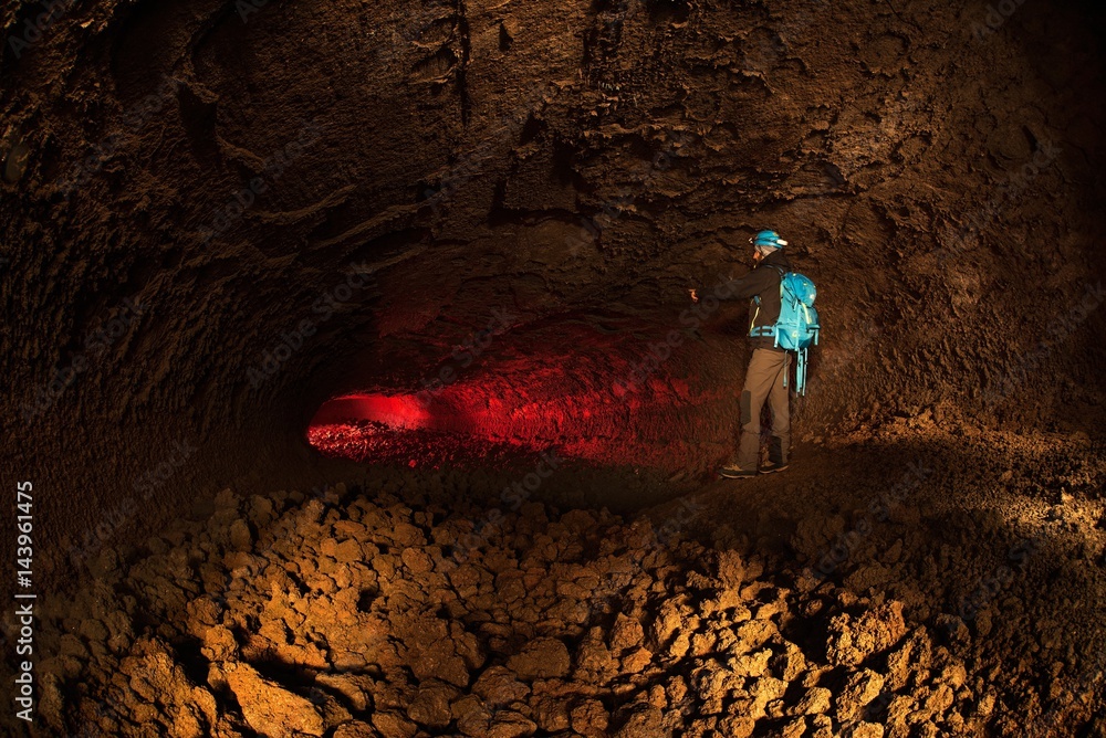 Etna volcano, Catania, Sicily, Italy. Man exploring an underground lava ...