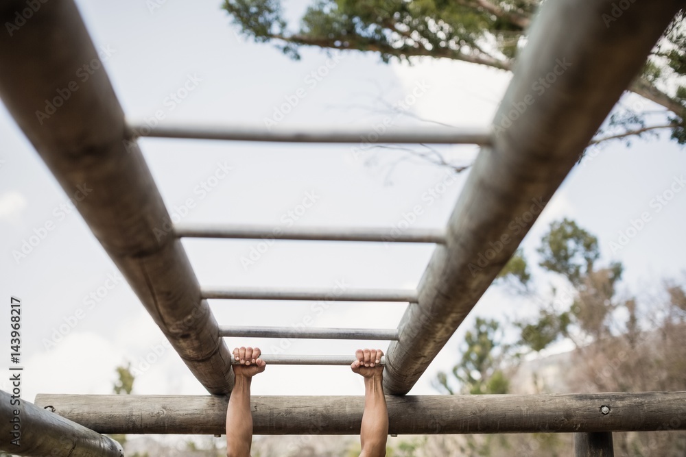 Fit man climbing horizontal bars during obstacle course Stock Photo ...