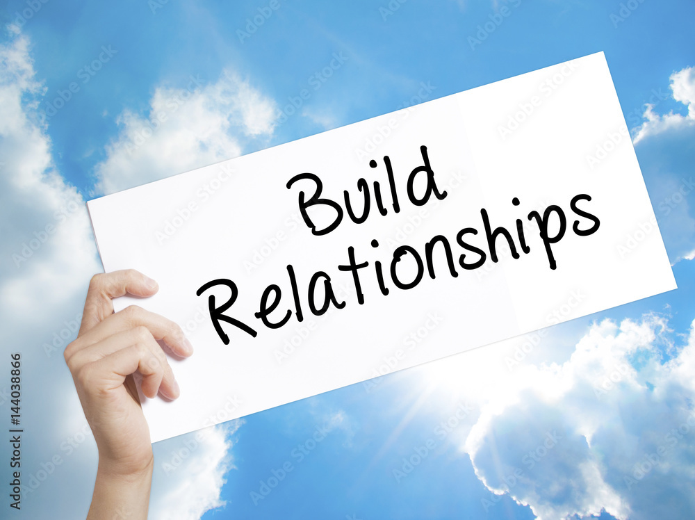 Build Relationships Sign on white paper. Man Hand Holding Paper with ...