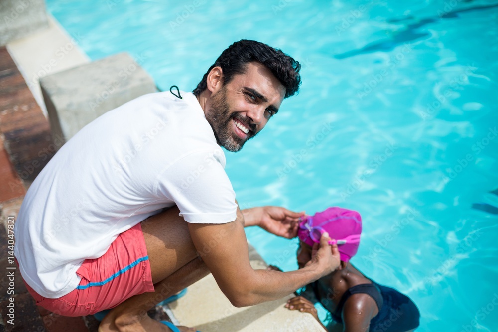 Male instructor assisting girl at poolside Stock Photo | Adobe Stock
