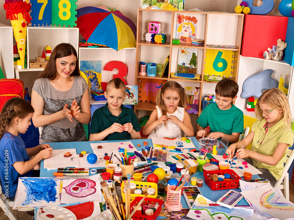 Plasticine modeling clay in children class. Teacher teaches kids play ...