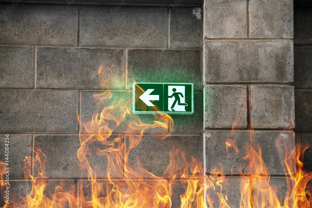 Emergency Fire Exit on the stone wall with fire flames Stock Photo ...