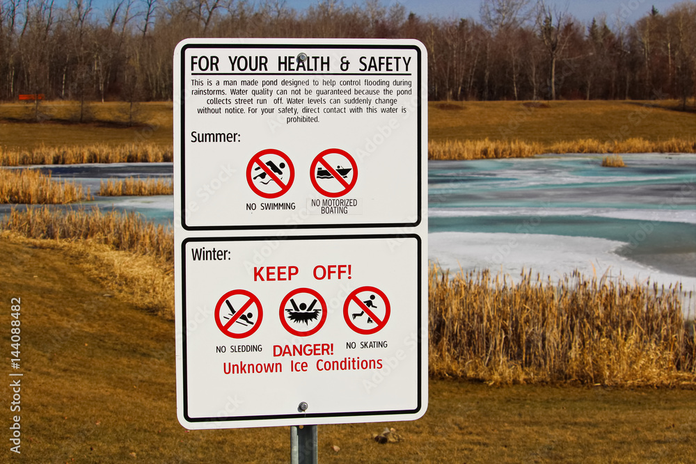 Warning signs around storm drainage pond Stock Photo | Adobe Stock