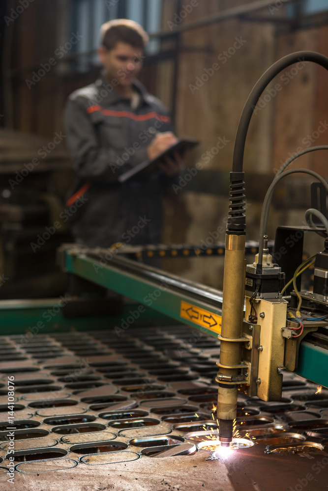 Industrial worker operating plasma cutter at the metal factory Stock ...