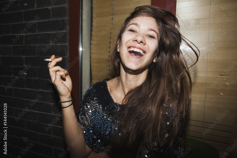 Laughing young woman smoking a cigarette Stock Photo | Adobe Stock