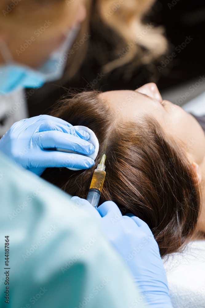 Needle mesotherapy. Cosmetic been injected in woman's head. Thrust to ...