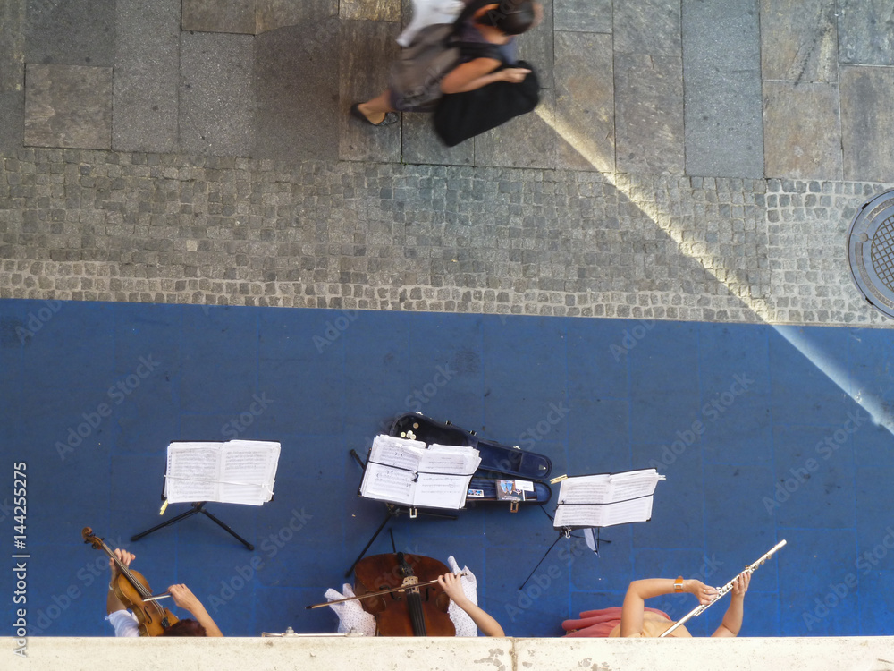 Female trio playing classical music on the street, bird's eye view ...