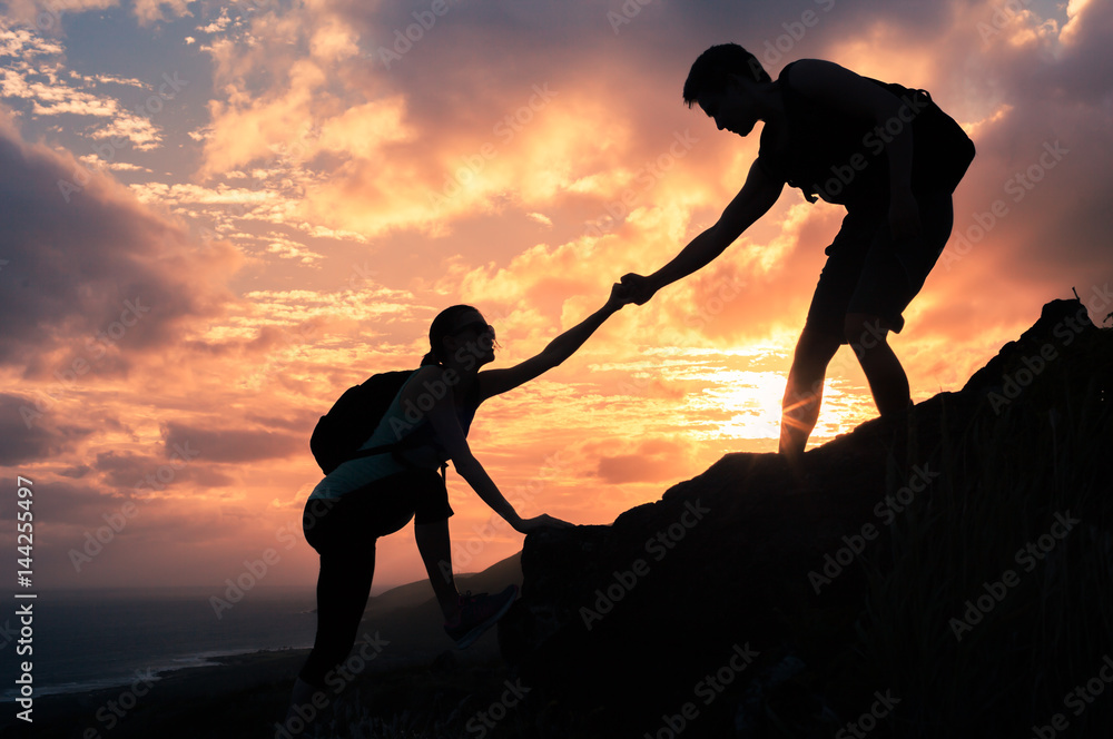 Team work. Man and woman helping each other climb up a mountain. Giving ... Team work. Man and woman helping each other climb up a mountain. Giving ...