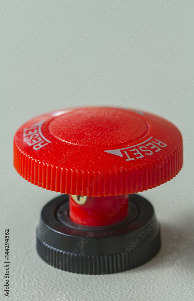 Red emergency stop and reset button on control panel for machine ...