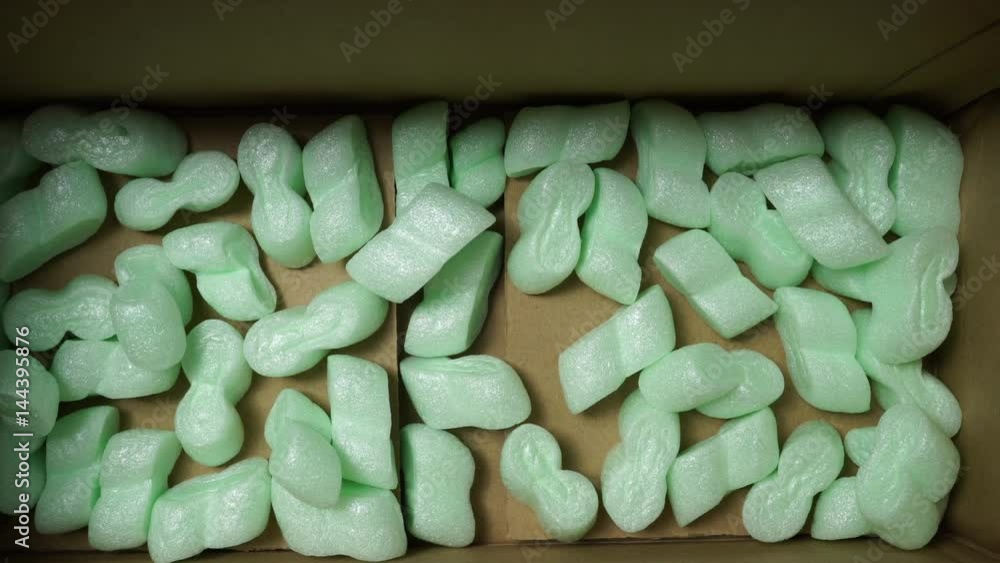Cardboard box with green bubbly plastic protective granules. Safe ...