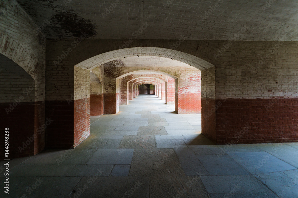 Masonry arched hallway stretching away into the darkness. Typical of ...