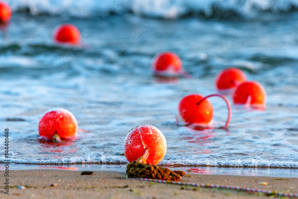 Water area enclosure garland of red round floats on the rope on sea ...