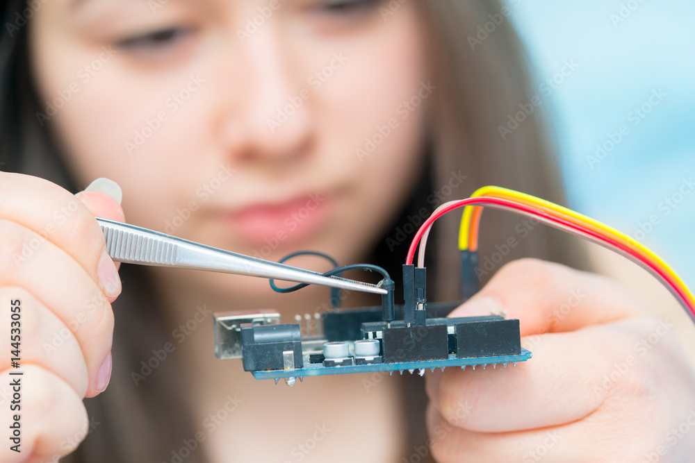 Student girl in electronics laboratory, experiment with microcontroller ...