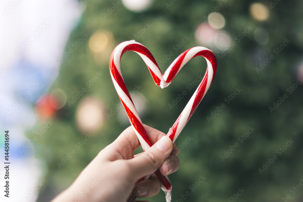 Candy canes in the shape of heart on a hand, on the background of ...