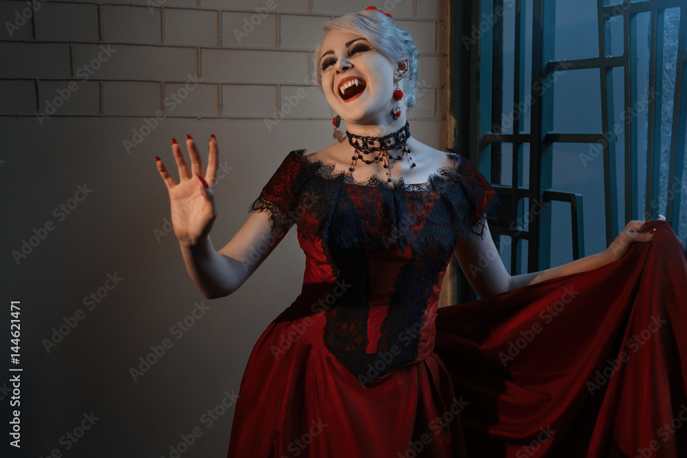 Woman in red dress with vampire grin, Victorian style. Stock Photo ...