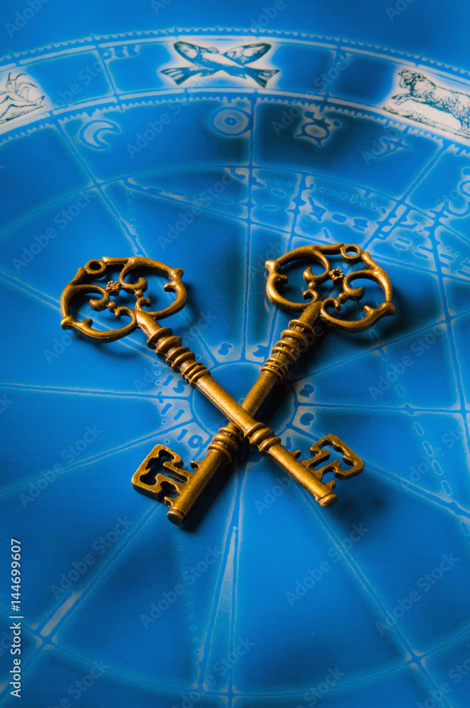 key lying on blue horoscope with zodiac symbols like a concept ...