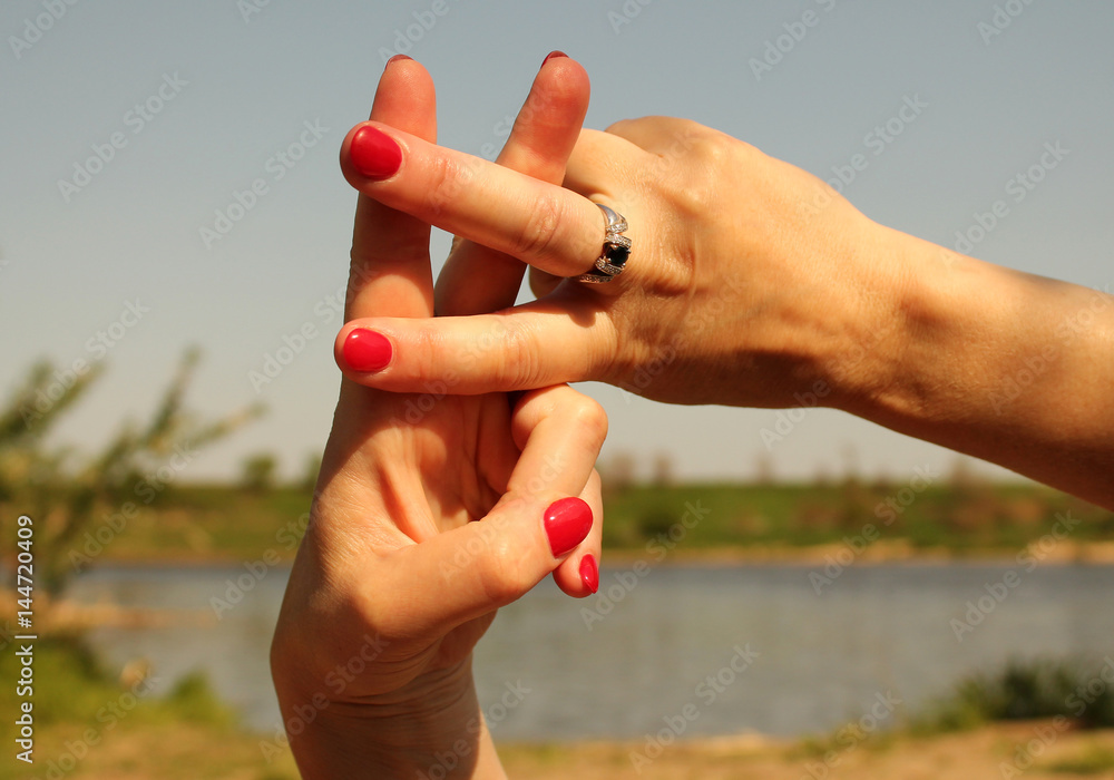 Woman hands showing hash symbol against the backdrop of summer water ...