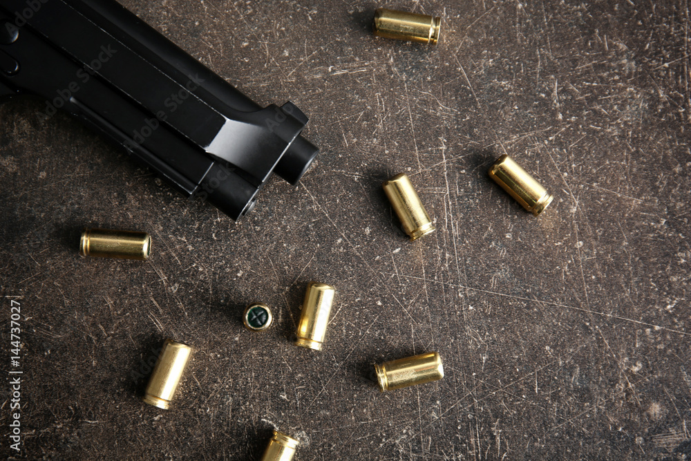 Bullets and gun on gray table Stock Photo | Adobe Stock