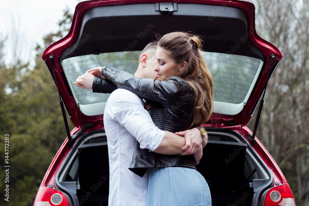 Beautiful guy with a girl hug, stand near the car, closed their eyes ...