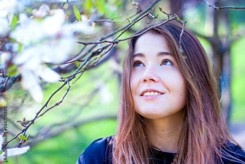 Beautiful girl without makeup in a blooming garden. Woman with long ...