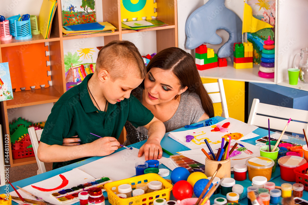 Small students girl and boy with teacher painting in art school class ...