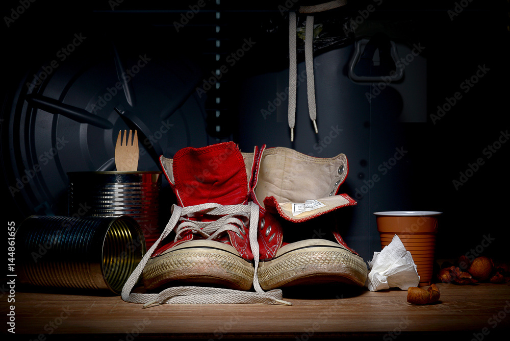 Red old sneakers from a garbage can on the background of garbage. Stock ...