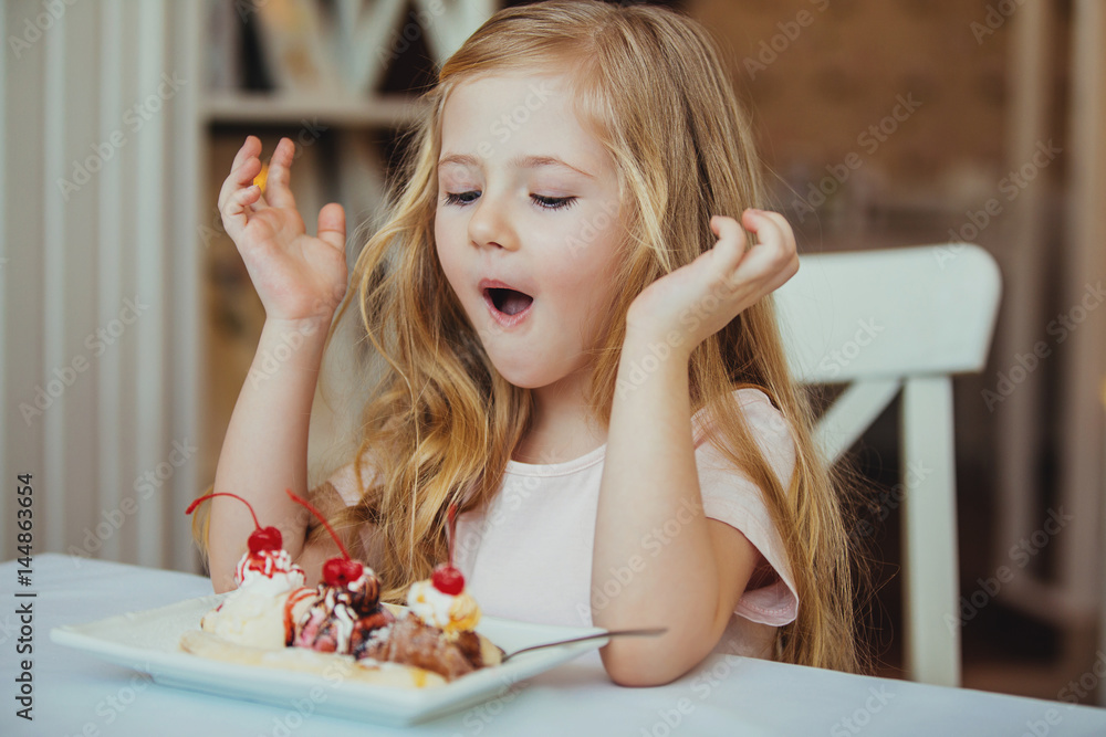 Happy surprised little girl serving ice cream sundae in your coffee ...