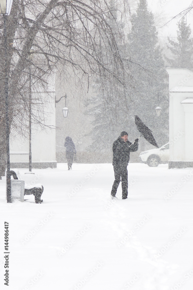 Bad weather in a city: a heavy snowfall and blizzard in winter ...