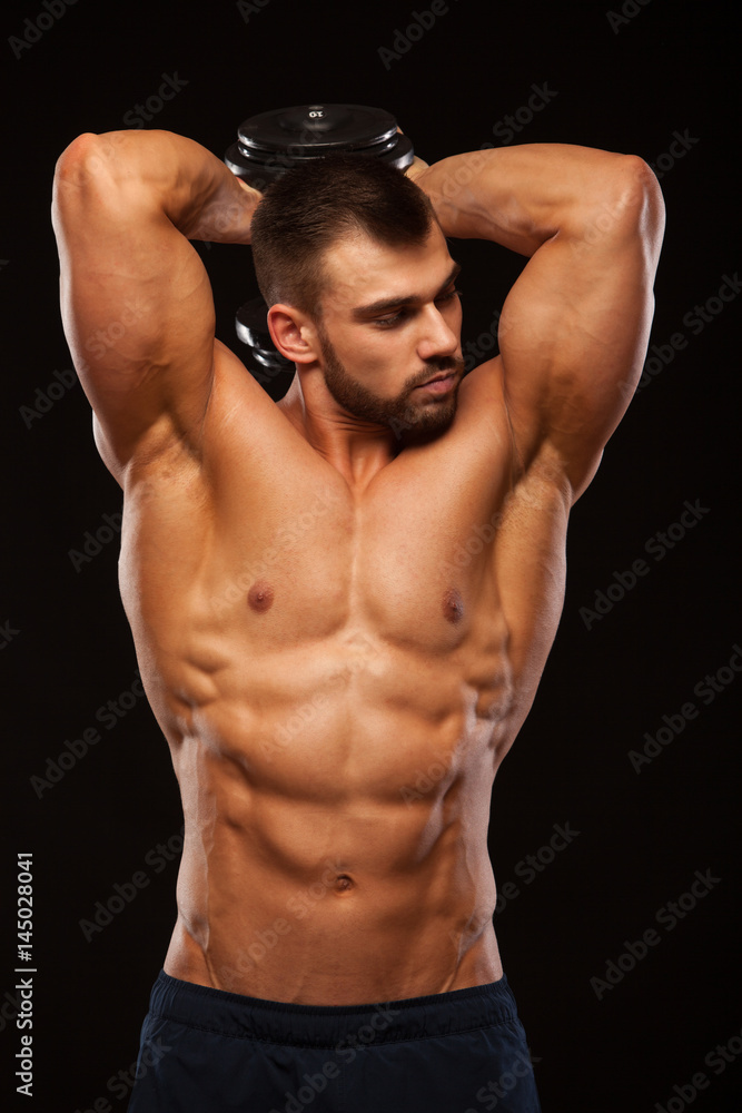 Strong man making exercises on triceps with a dumbbell. Close up shot ...