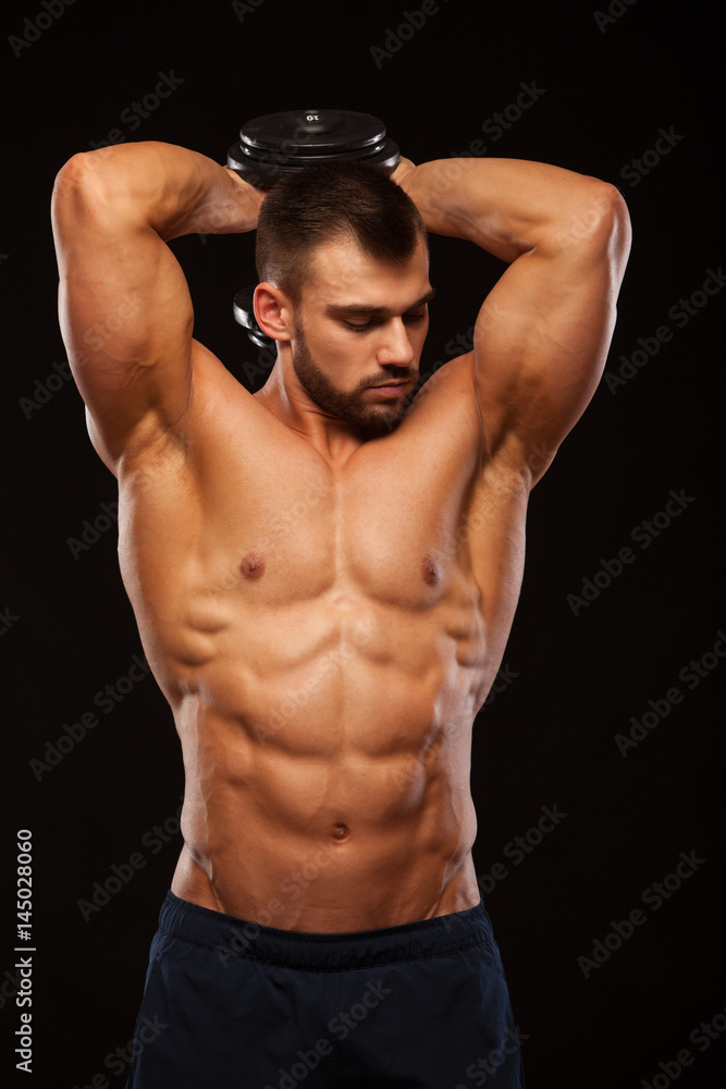 Strong man making exercises on triceps with a dumbbell. Close up shot ...
