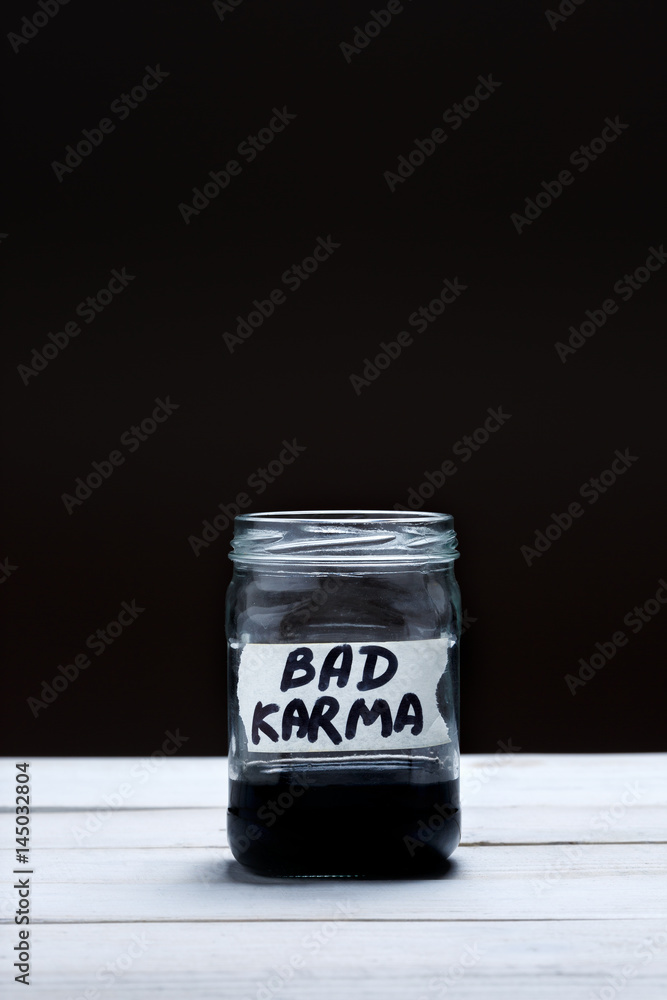 Bad Karma - an inscription on the label of a glass jar with a liquid of ...