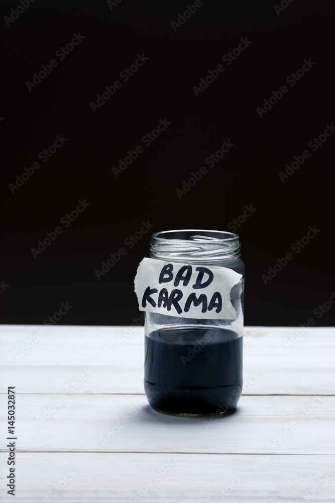 Bad Karma - an inscription on the label of a glass jar with a liquid of ...