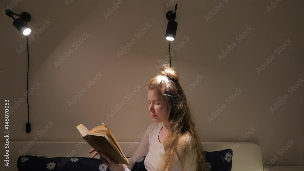 Girl reading book and showing happy emotions. Blonde girl sitting on ...