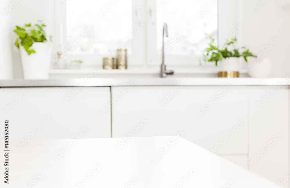 table with blurred kitchen interior detail of a kitchen sink in teh ...