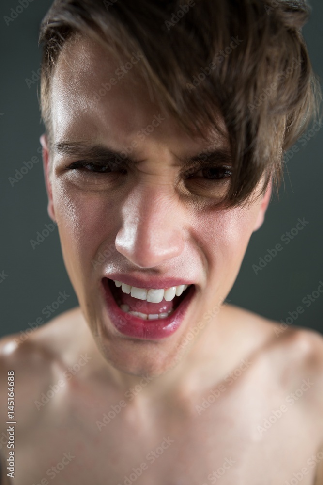 Shirtless androgynous man crying against grey background Stock Photo ...