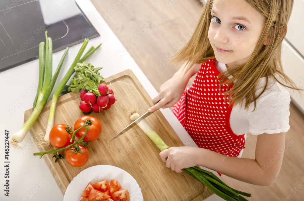 Happy little girl cooking in the kitchen with vegetables Stock Photo ...
