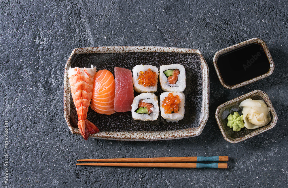 Sushi Set nigiri and sushi rolls in dark ceramic plate with soy sauce ...