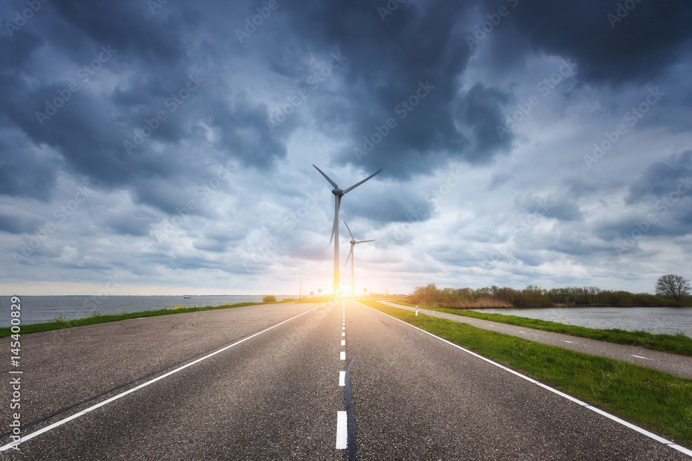 Beautiful asphalt road with wind turbines generating electricity at ...