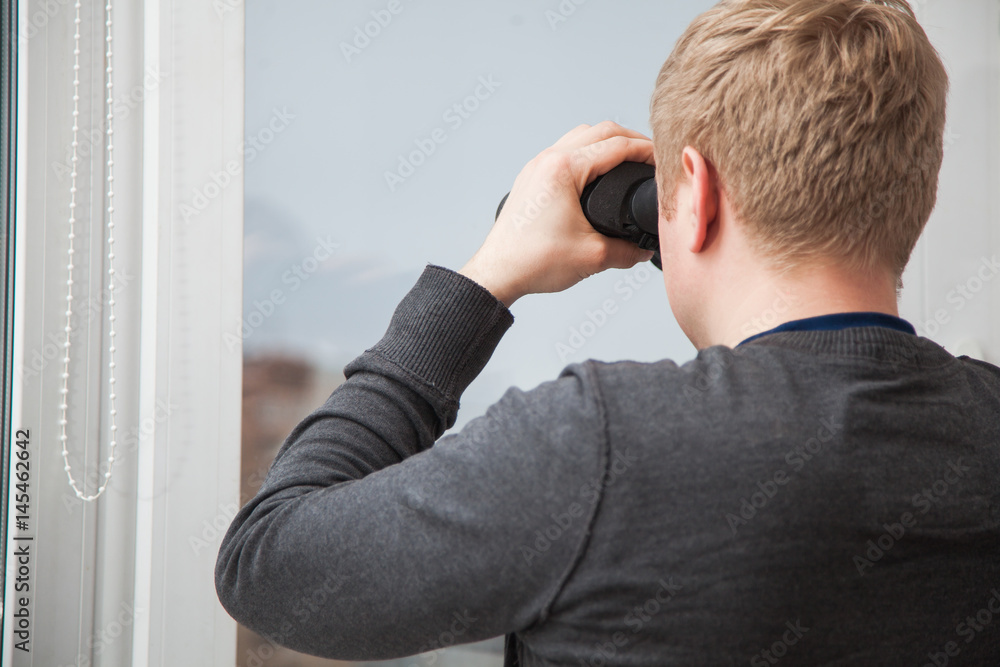 Young handsome man looking through window with binocular glasses Stock ...